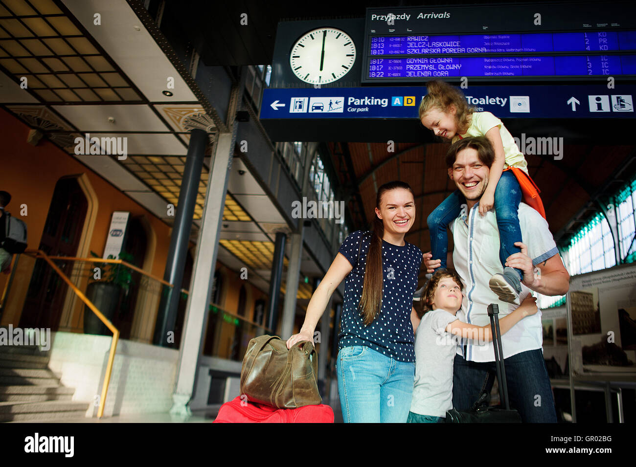 Fröhliche junge Familie am Bahnhof. Vater, Mutter, Sohn und Tochter ... Fröhliche junge Familie am Bahnhof. Vater, Mutter, Sohn und Tochter ...