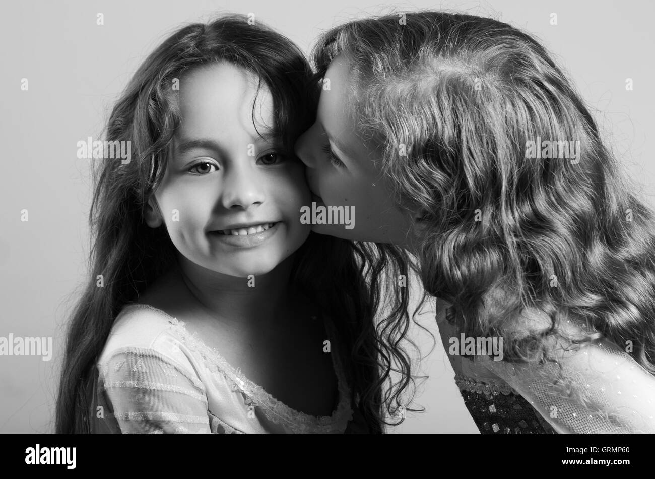 Two young sisters kissing -Fotos und -Bildmaterial in hoher Auflösung – Alamy