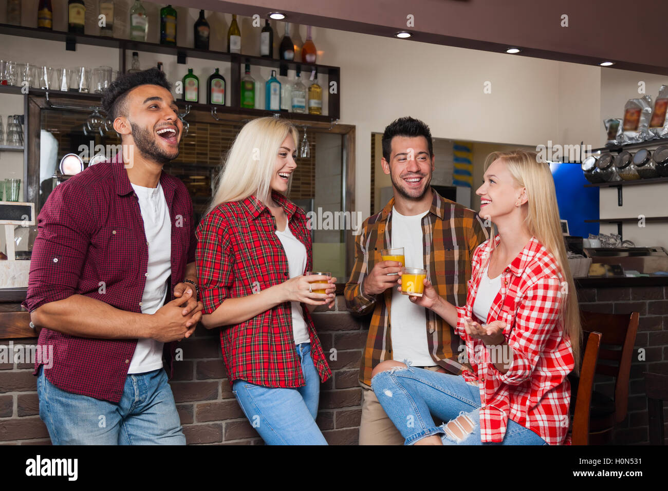 Menschen Freunde trinken Orange Saft reden lachend sitzen am Bar-Theke ...