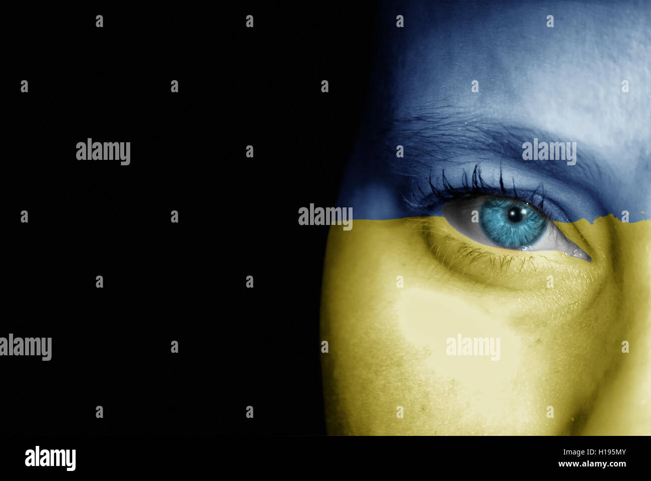 Eine junge Frau mit der Flagge der Ukraine gemalt auf ihr Gesicht auf ... Eine junge Frau mit der Flagge der Ukraine gemalt auf ihr Gesicht auf ...