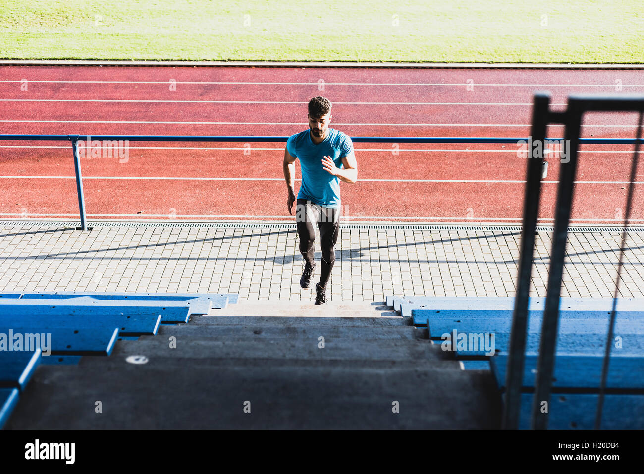 Sportler trainieren auf der Tribüne ein Leichtathletik-Stadion ...
