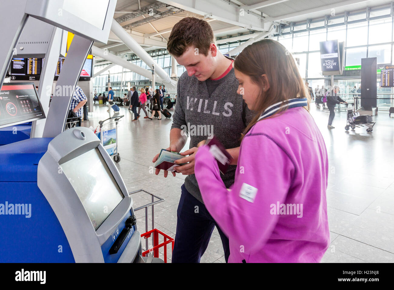 Ein junges Paar Check-In und drucken Sie ihre Bordkarten, Flughafen ...