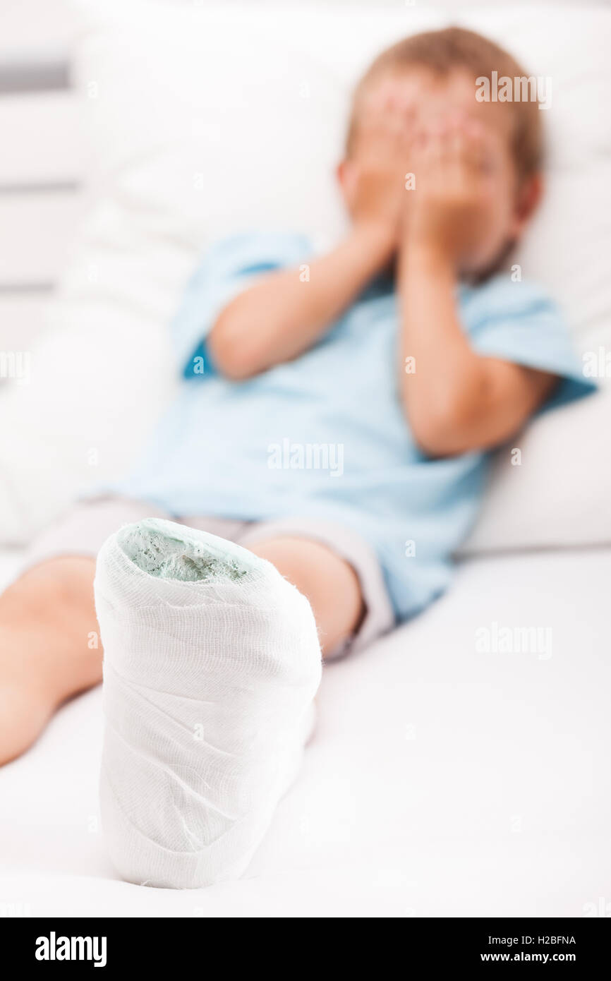 Kleines Kind Junge mit Gips Bandage am Bein Ferse Fraktur oder br ...