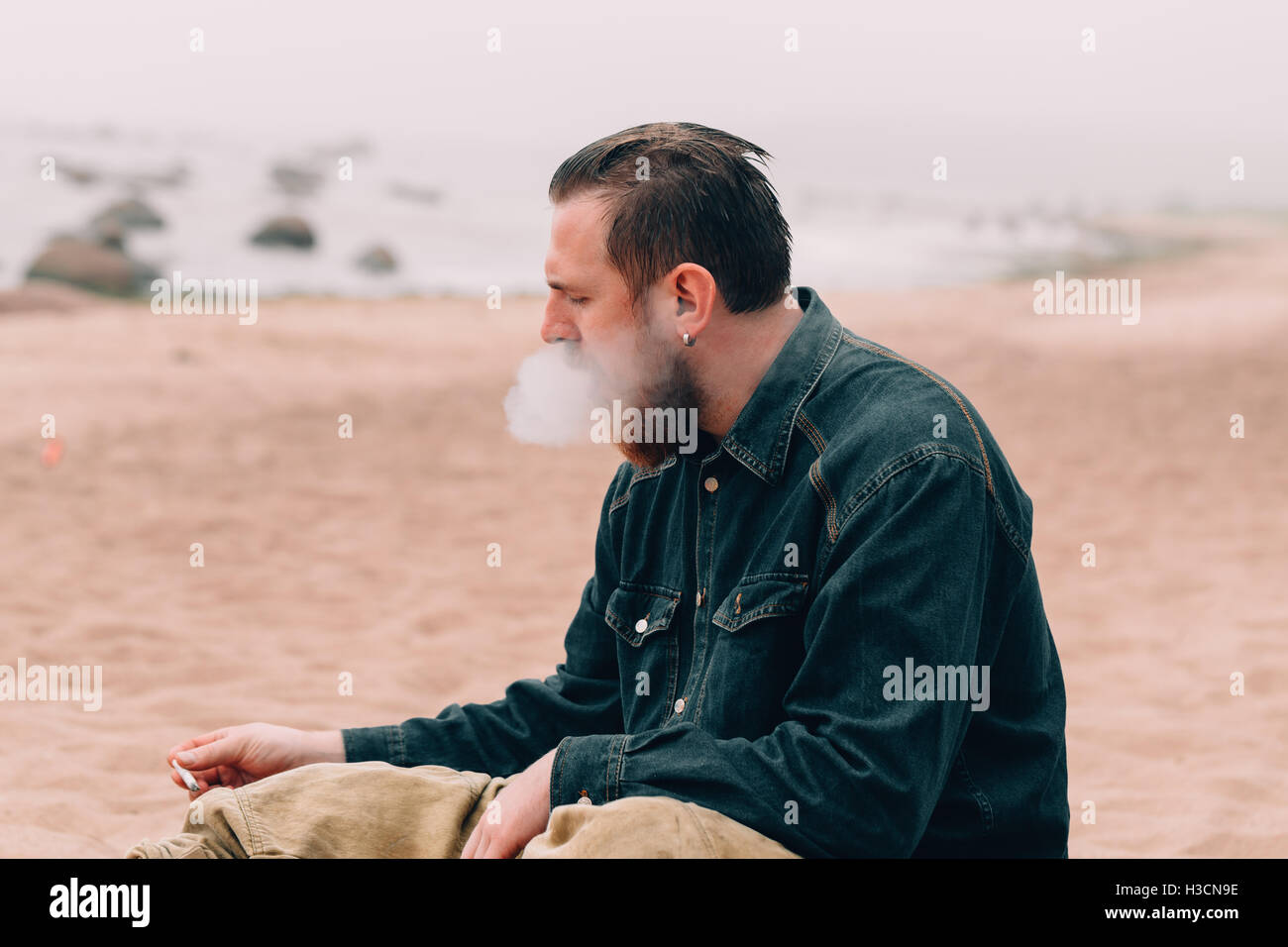 Man smoking beach -Fotos und -Bildmaterial in hoher Auflösung – Alamy