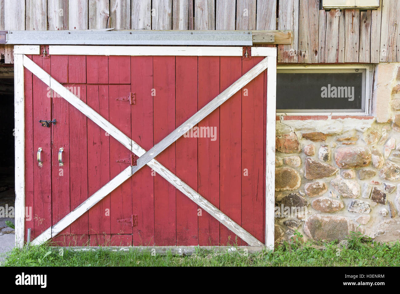 Teilweise offene rote Scheunentor in eine verwitterte Scheune ...