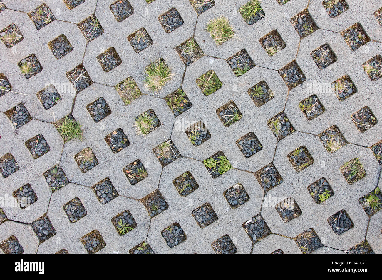Pflasterstein in einem Gitter Form und grünen Rasen in die Löcher ...