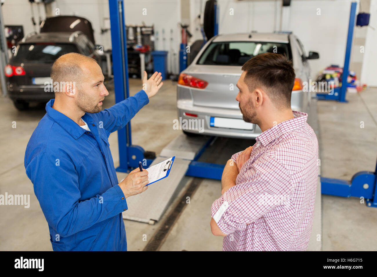 Automechaniker mit Zwischenablage und Mann an dem Auto Shop ...
