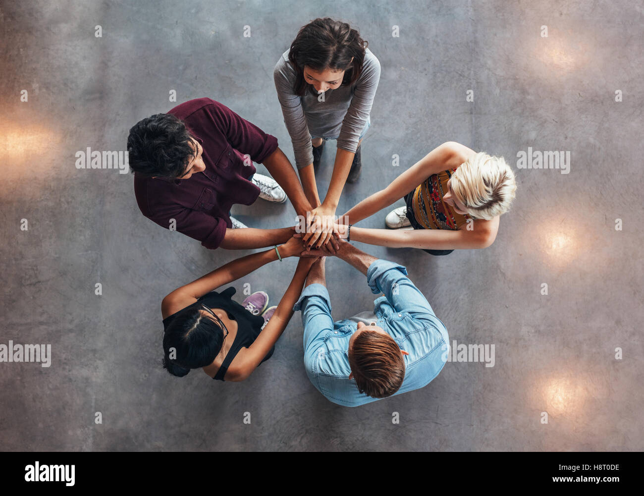 Junge Menschen ihre Hände übereinander symbolisiert Einheit und ...