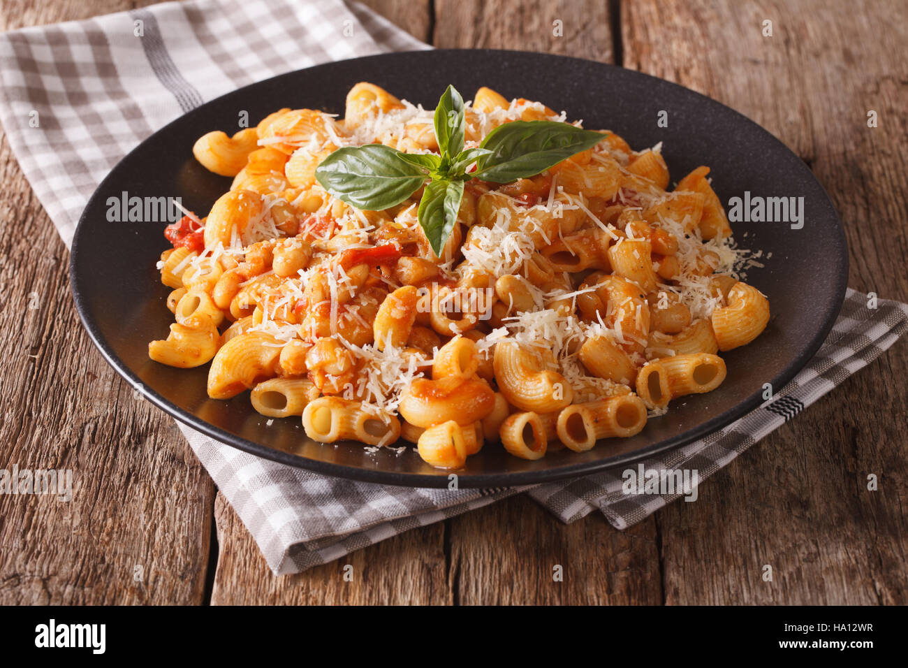 Gomiti Pasta mit Tomaten, Bohnen und Parmesan mit einer Großaufnahme ...