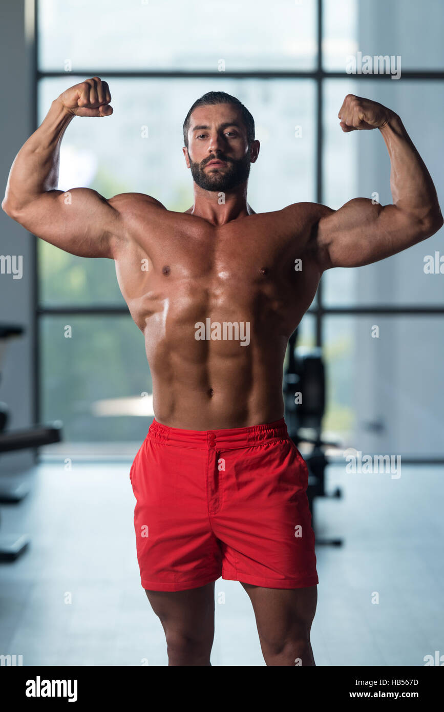 Porträt einer Fit Jüngling zeigen vorderen Doppel Bizeps Pose ...