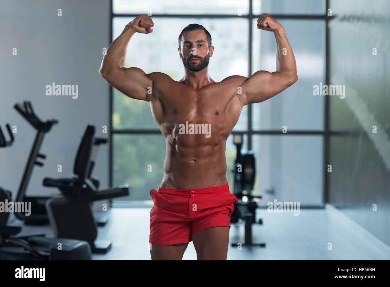 Porträt einer Fit Jüngling zeigen vorderen Doppel Bizeps Pose ...