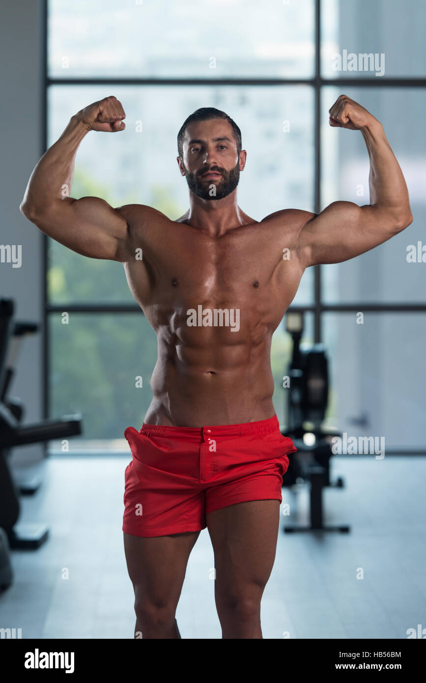 Porträt einer Fit Jüngling zeigen vorderen Doppel Bizeps Pose ...