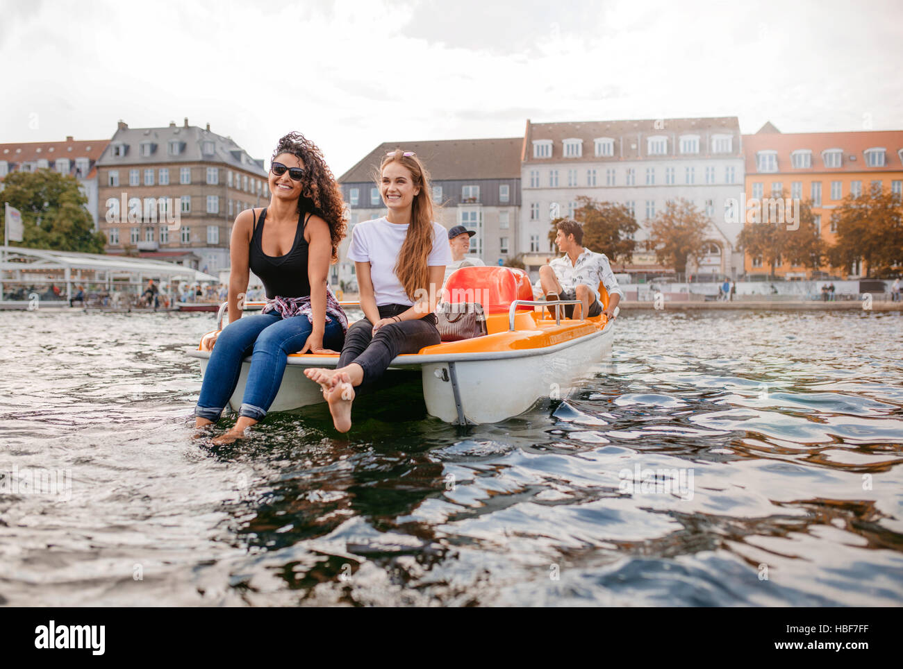 Schuss von Jugendlichen auf Tretboot in See. Frauen sitzen auf ...