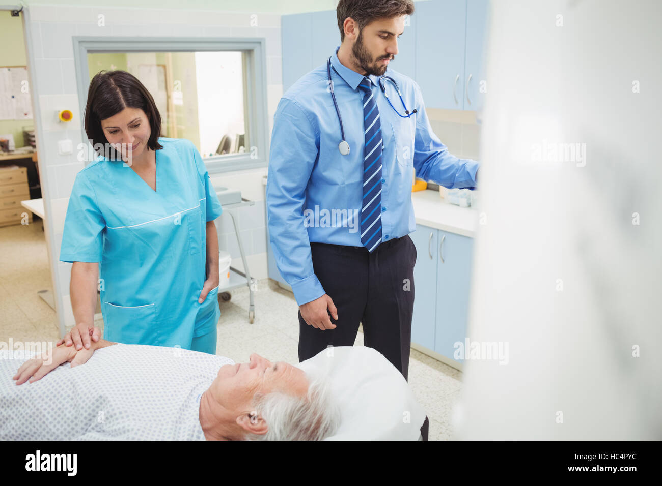 Ein Patient wird in ein MRT-Gerät beim Arzt und Techniker gerade ...