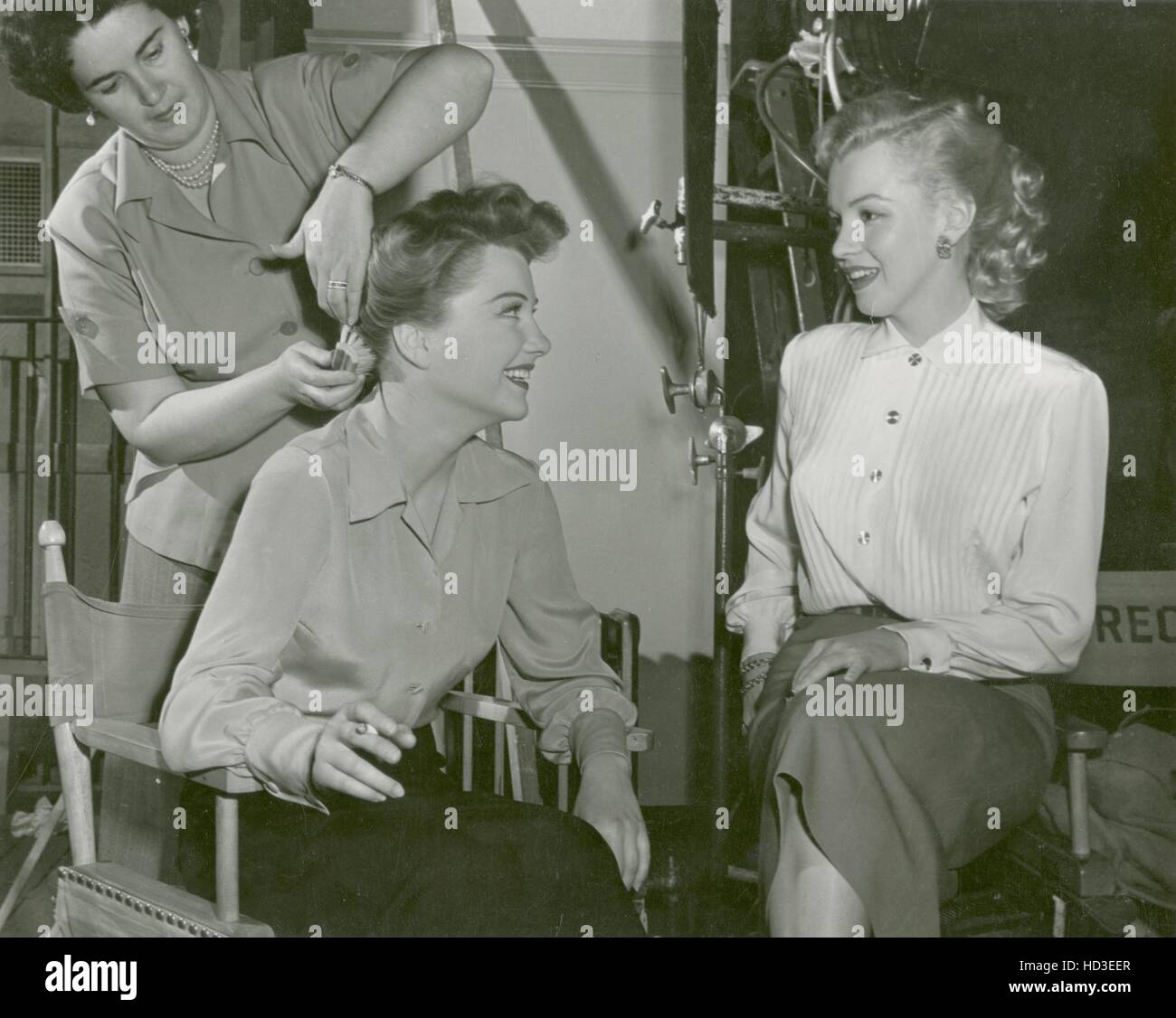 Friseur Kay Reed kümmert sich um Anne Baxter, wer mit Marilyn Monroe ...
