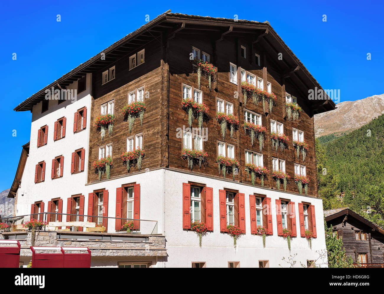 Traditionelle Schweizer Chalet mit Blumen auf dem Balkon in Zermatt Resort der Schweiz im Sommer ...