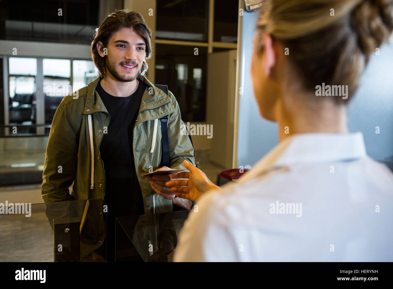 Mann zeigt seine Bordkarte am Check-in Schalter am Flughafen ...