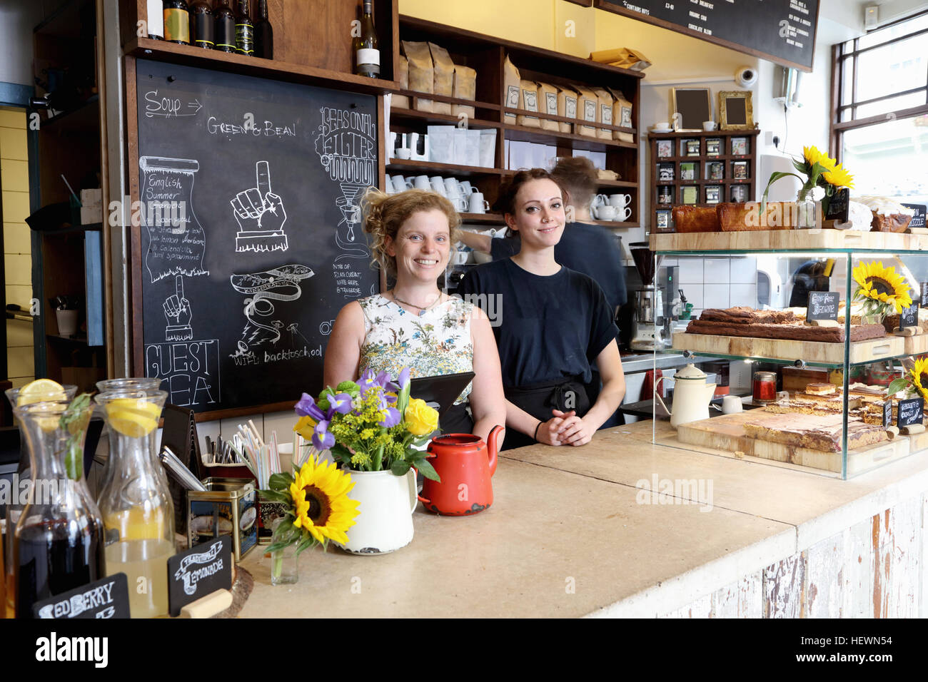 Kolleginnen und Kollegen am Schalter im Café mit Blick auf die Kamera ...