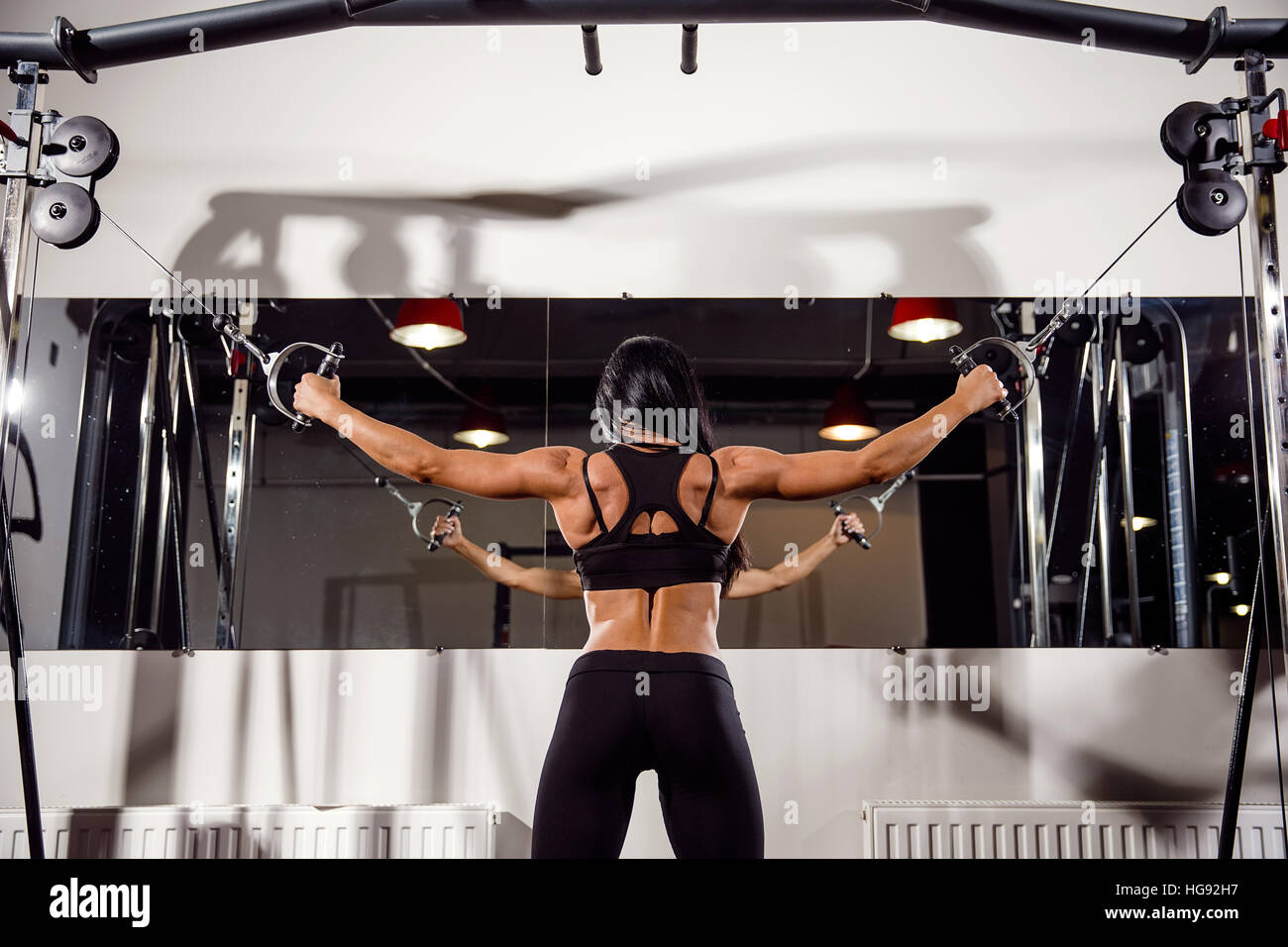Frau Muskeln auf Kabel-Maschine im Fitness-Studio Stockfotografie - Alamy