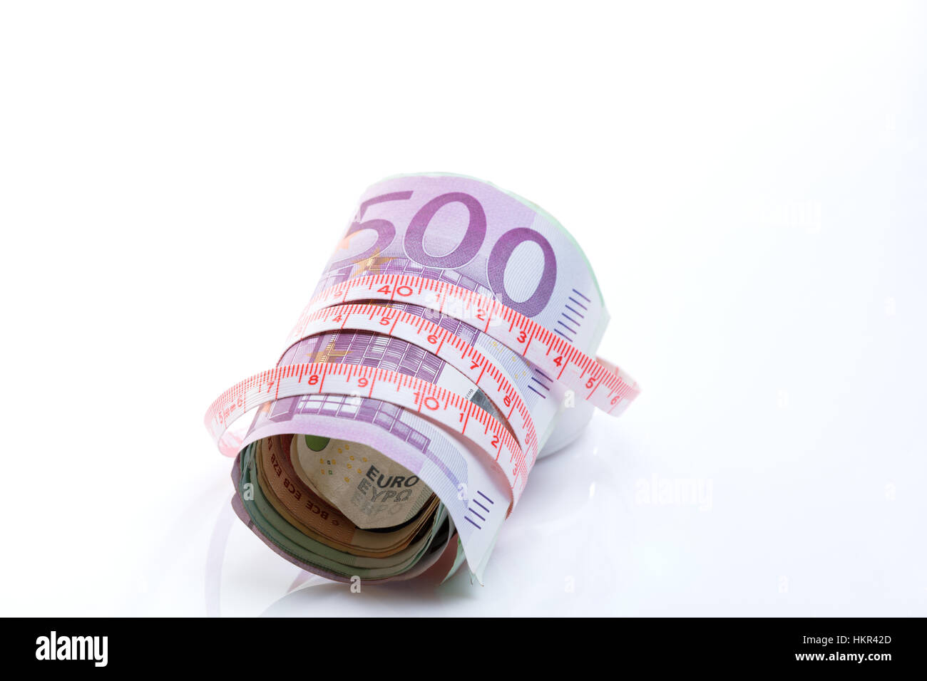 Rollen von Euro mit einem Meter Band um sie herum auf einem weißen ...