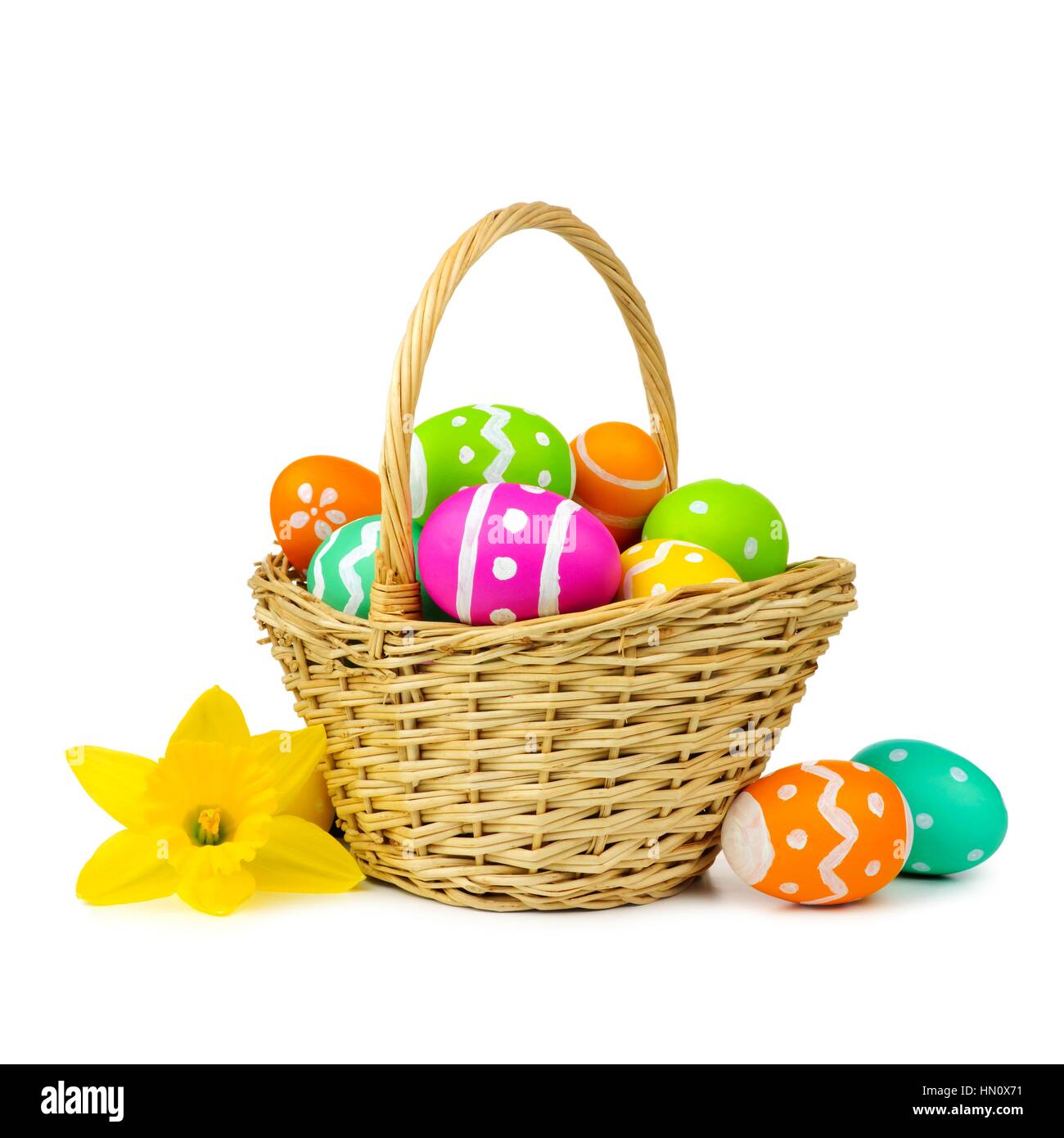 Osternest mit bunten Eiern und Narzissen auf weißem Hintergrund ...