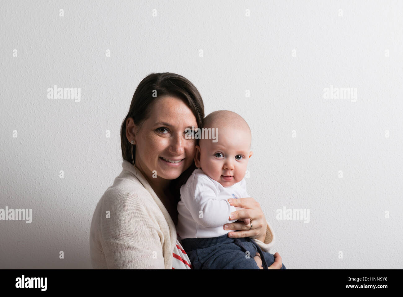 Schöne Mutter mit Baby Sohn in die Arme. Studio gedreht Stockfotografie ...