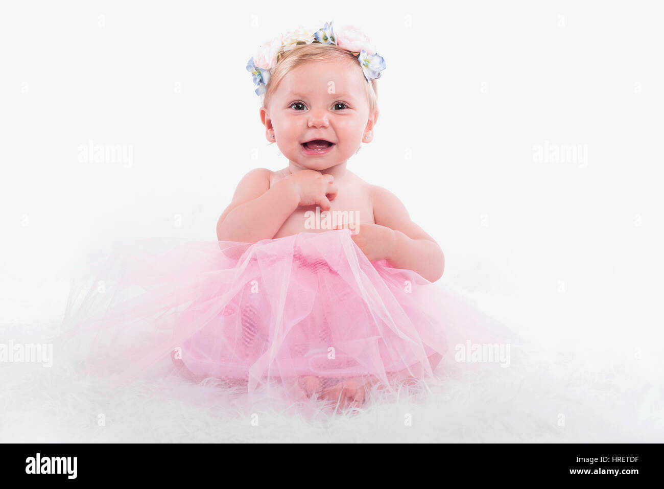 lustige Baby mit Blumen-Kranz. Babymädchen in Prinzessin Kostüm und ...