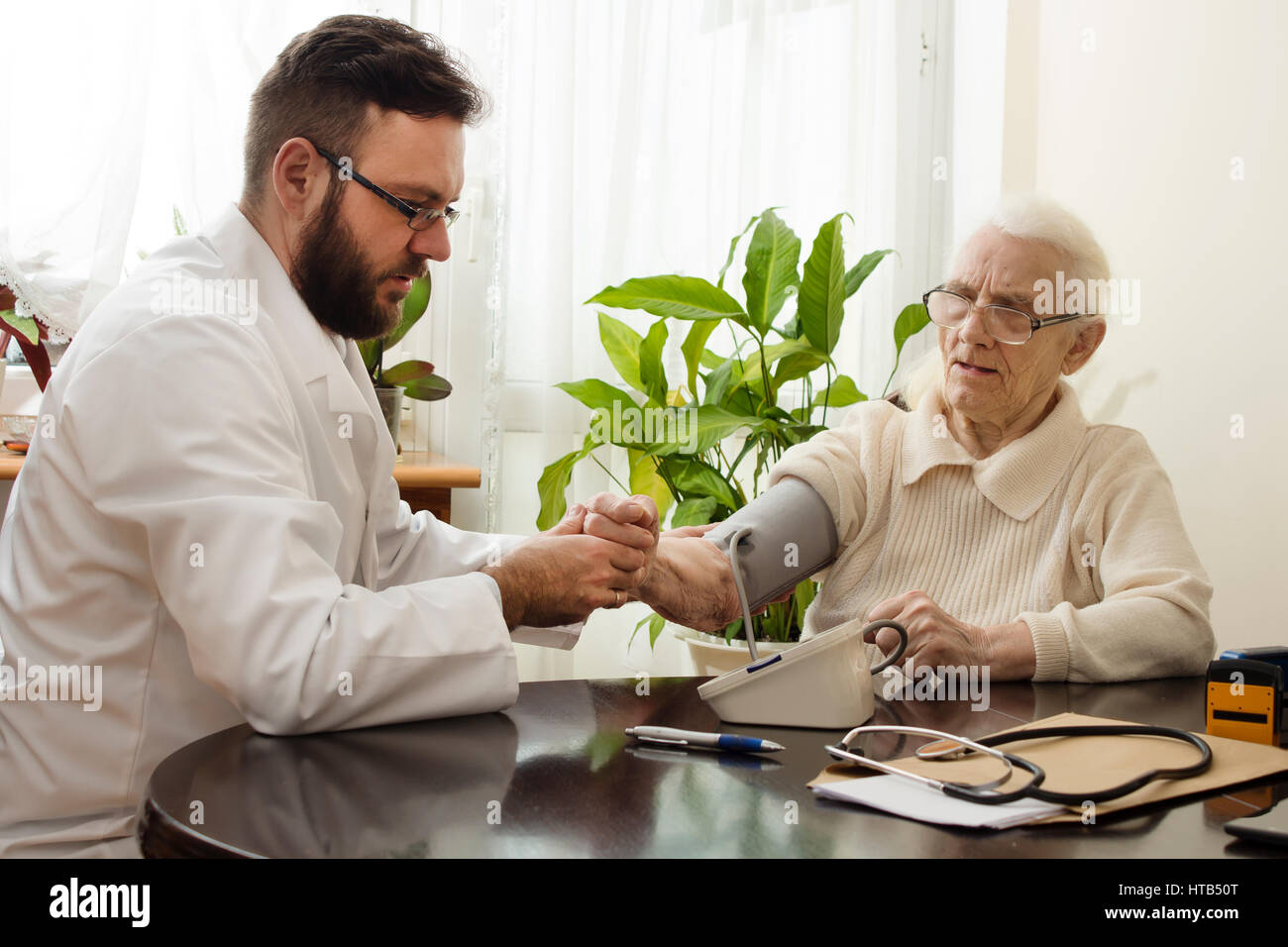 Eine private Arztpraxis. Geriater Arzt nimmt den Patienten und ihren ...