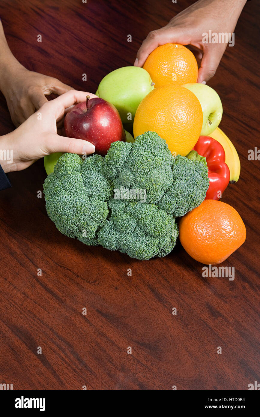 Menschen nehmen Obst aus Tabelle Stockfotografie - Alamy