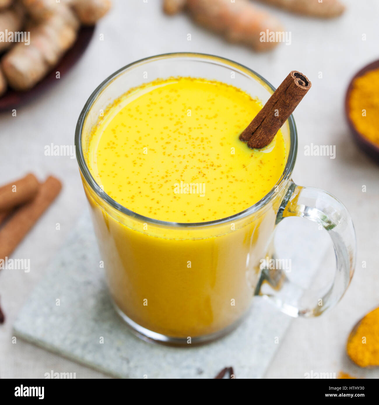 Kurkuma-Getränk, Latte, Tee, Milch mit Zimt in einen Glaskrug mit ...