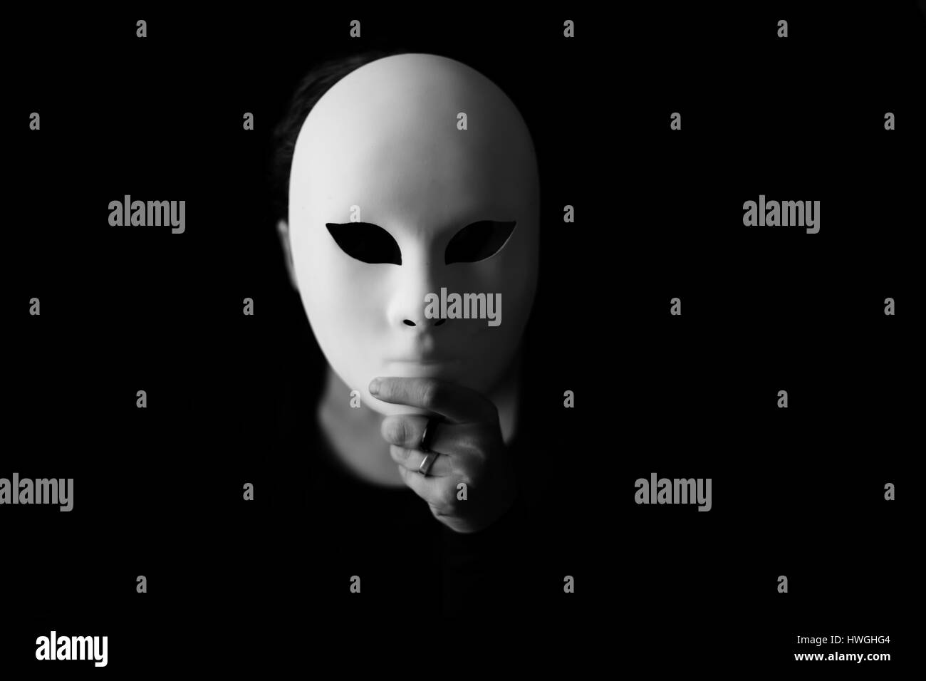 Frau mit Maske in der Hand vor Gesicht Stockfotografie - Alamy