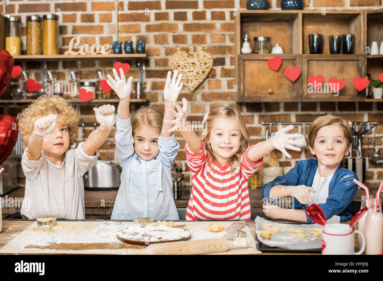 Entzückende glückliche Kinder kochen Kekse und Hände in Mehl ...
