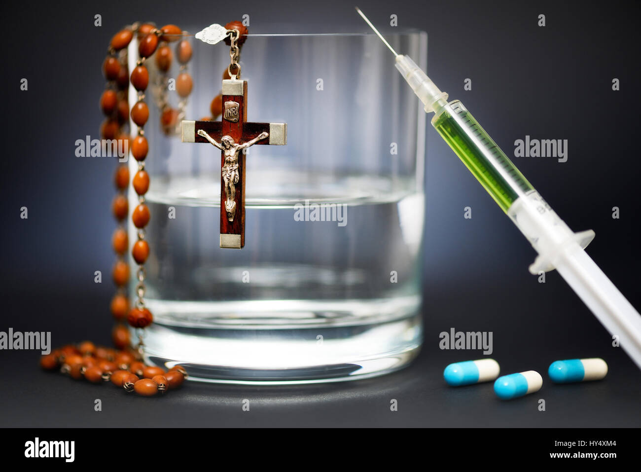 Wasserglas, Kreuz, Tabletten und Spritze, symbolische Foto Sterbehilfe ...