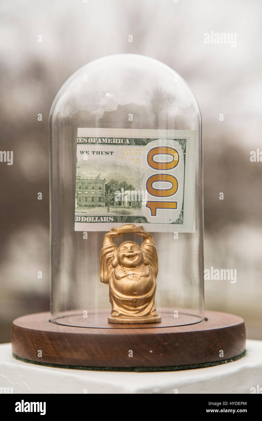 eine kleine goldene Buddha Figur stehend in einem Glas Kuppel hält ein ...