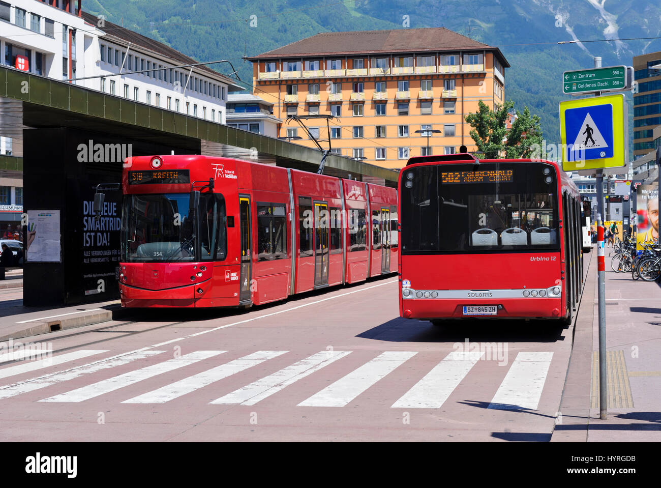 Einem roten Bus und eine rote elektrische Straßenbahn in Innsbruck Bus ...