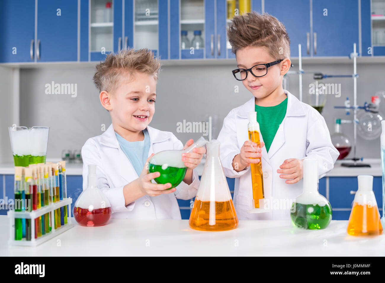 Kleine Jungs im Labor lächelnd Mäntel machen Experiment im chemischen ...