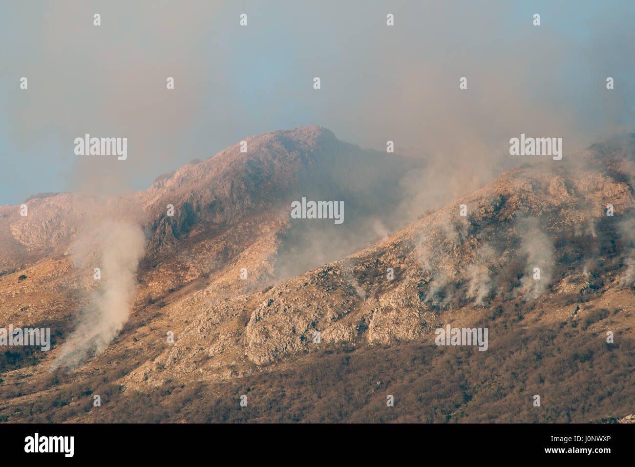 Feuer in den Bergen am Nachmittag. Rauch über die Berge. Budva ...