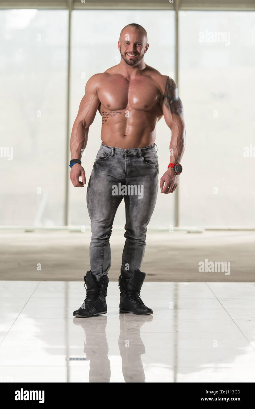 Hübscher junger Mann standhaft In Hosen und biegen Muskeln - muskulöse ...