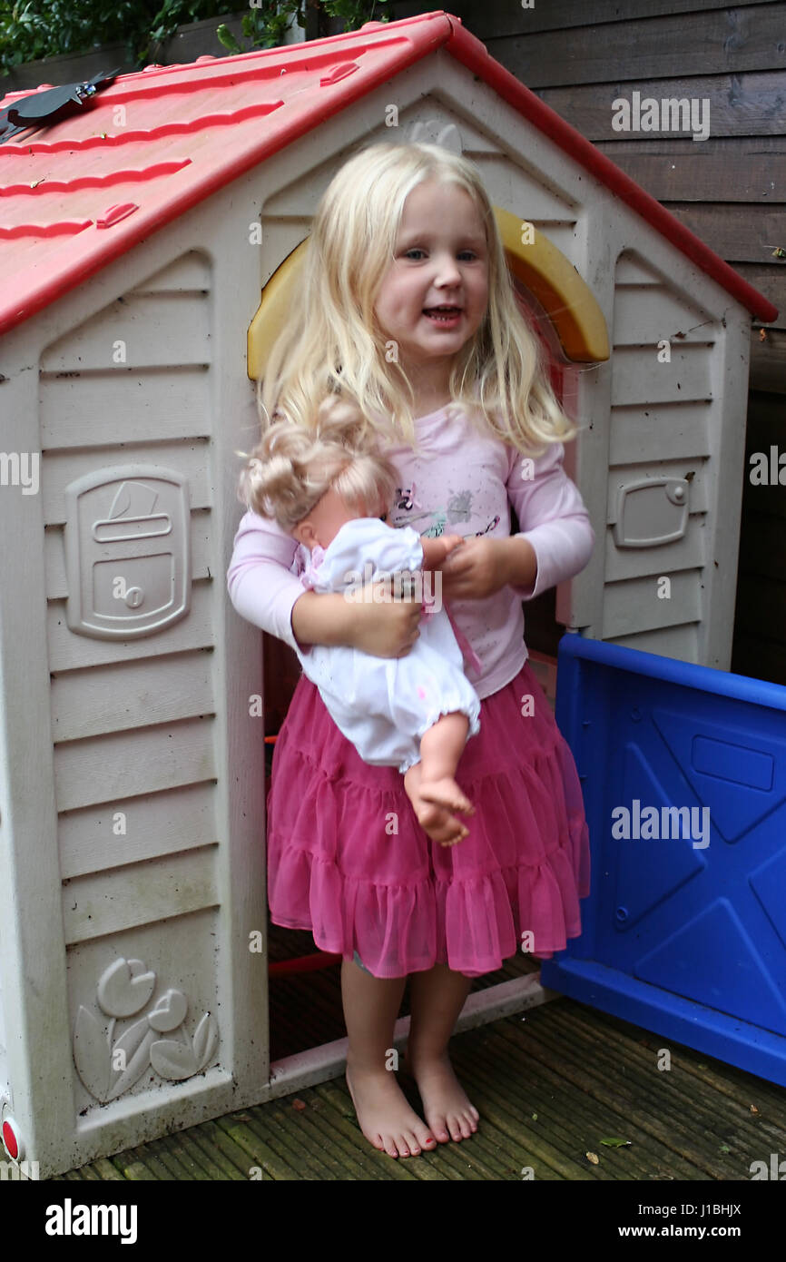Kleine Mädchen spielen mit ihrer Puppe im Garten Kinder spielen, Kinder ...