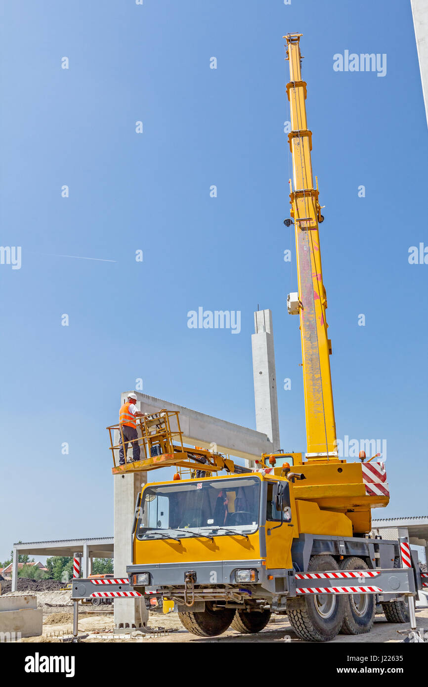 Mobiler Kran ist in Betrieb und Arbeiter ist Montage Beton Unterzug in ...
