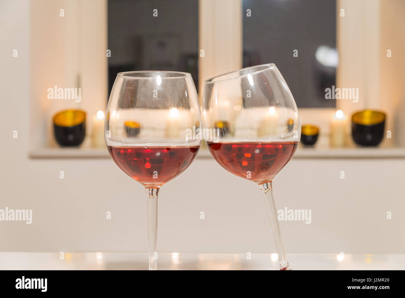 Zwei Gläser mit Rotwein auf weißen Tisch mit weißem Hintergrund und ...