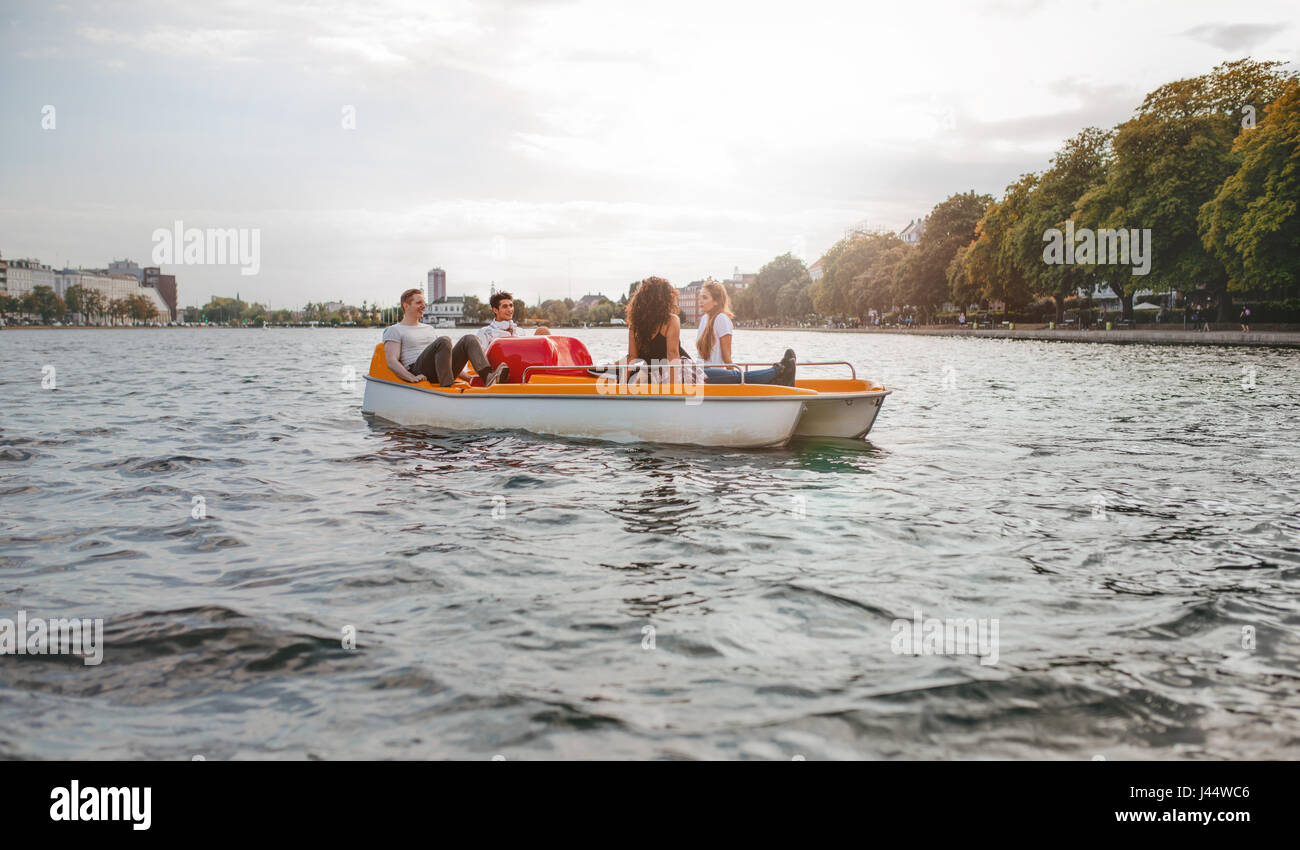 Im Freien Schuss von jungen Freunden sitzen im Tretboot Sommer genießen ...