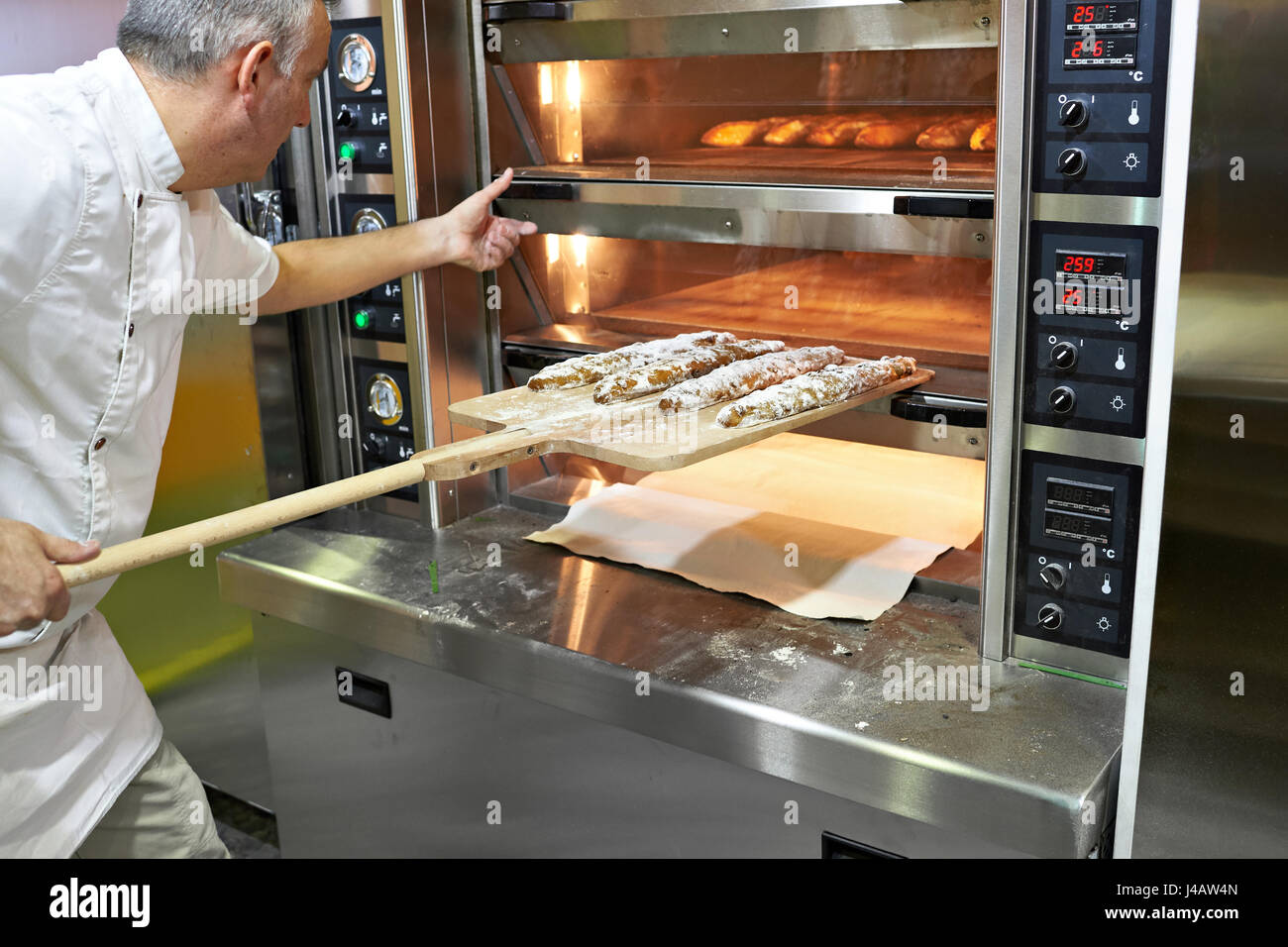 Bäcker backt Brot im Backofen Stockfotografie - Alamy