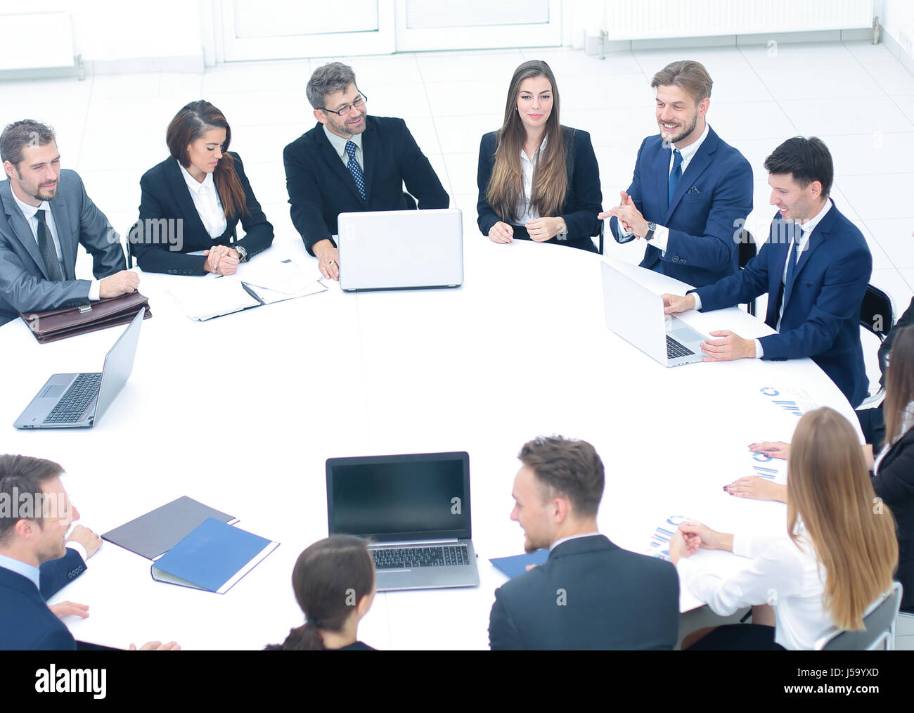 Chef und seine Business-Team sitzen an einem runden Tisch mit der ...