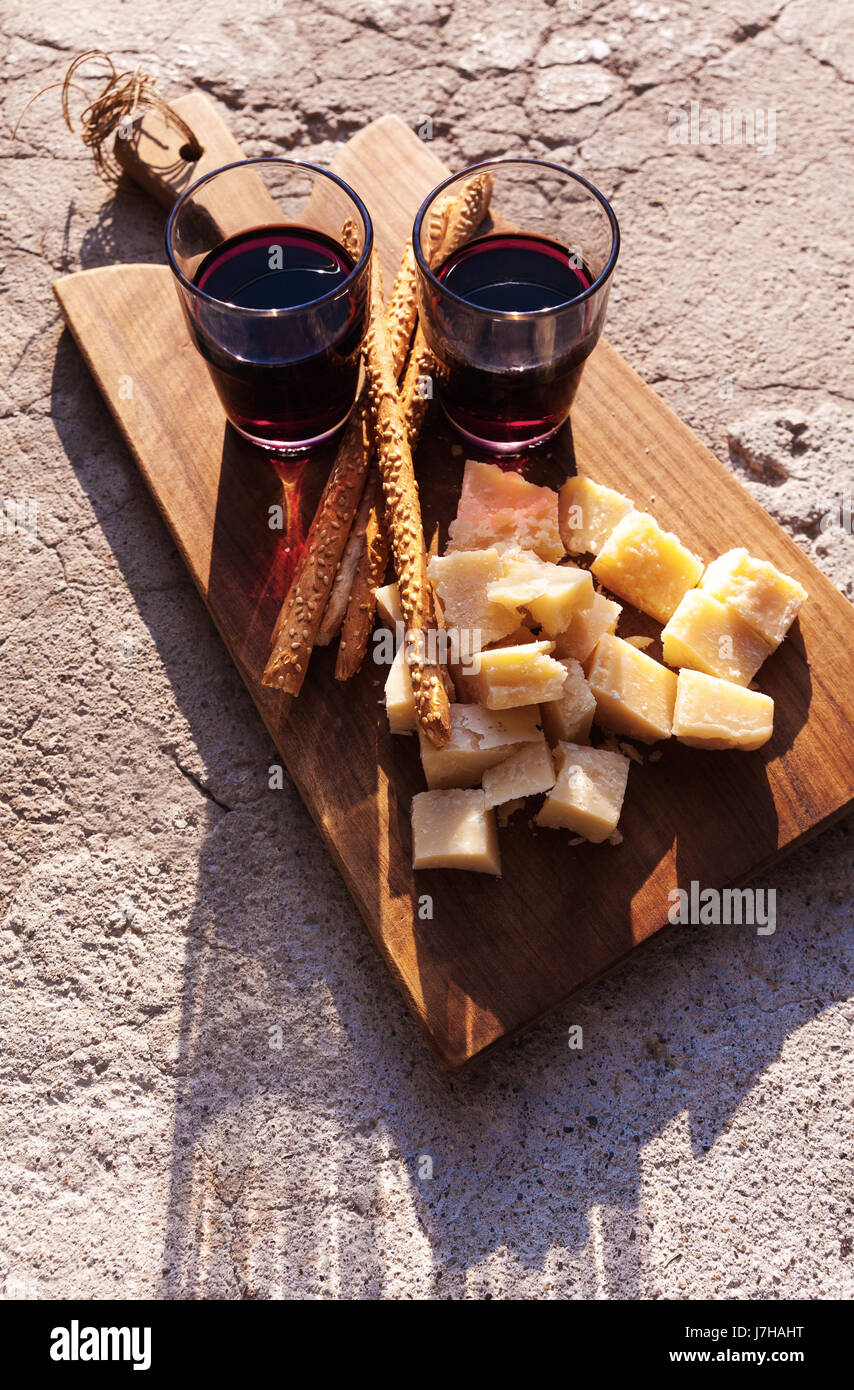Wein und Parmesan-Käse auf ein Schneidebrett im warmen Licht der ...