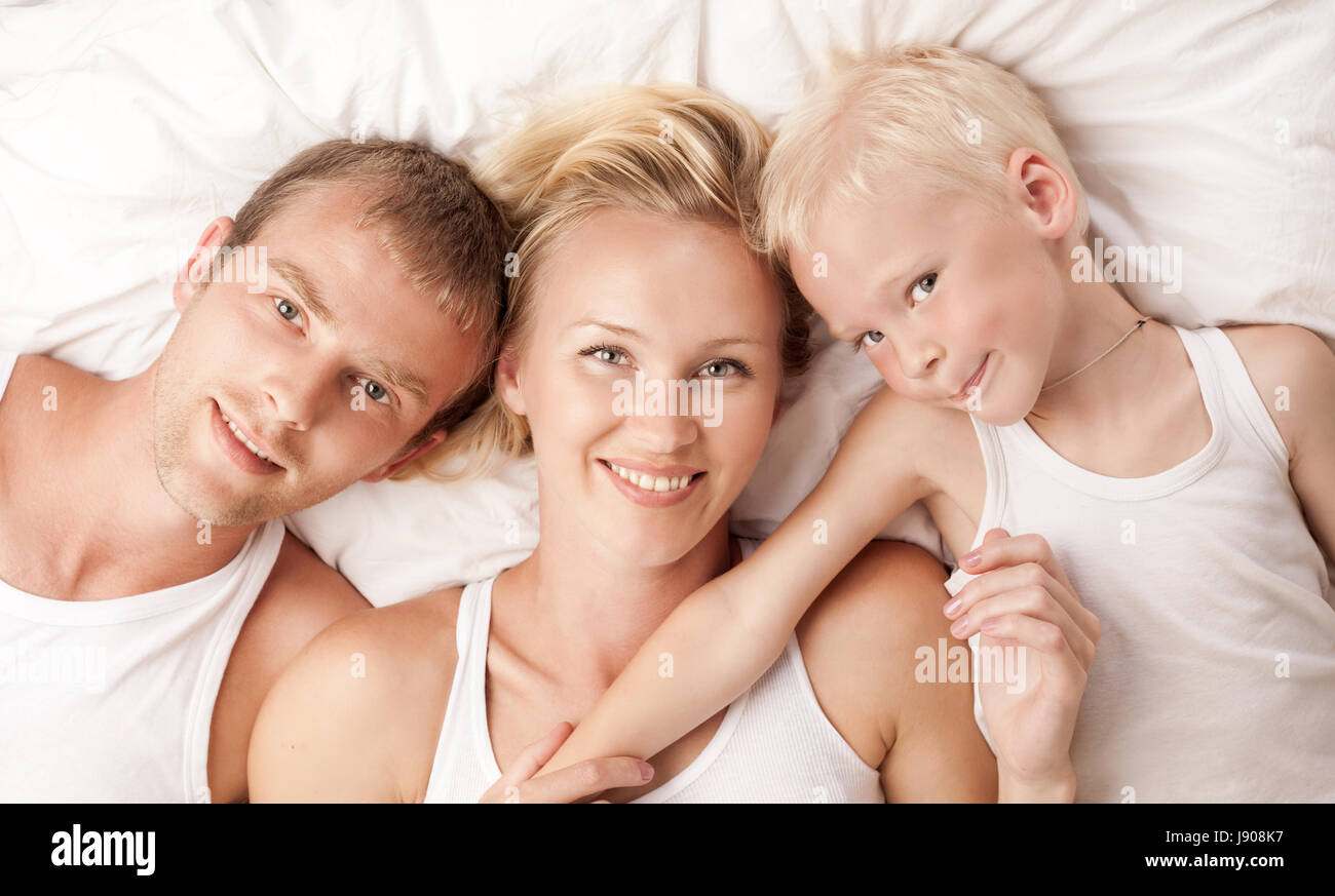 glückliche Familie: Vater, Mutter und Sohn im Bett zu Hause entspannen Stockfotografie - Alamy