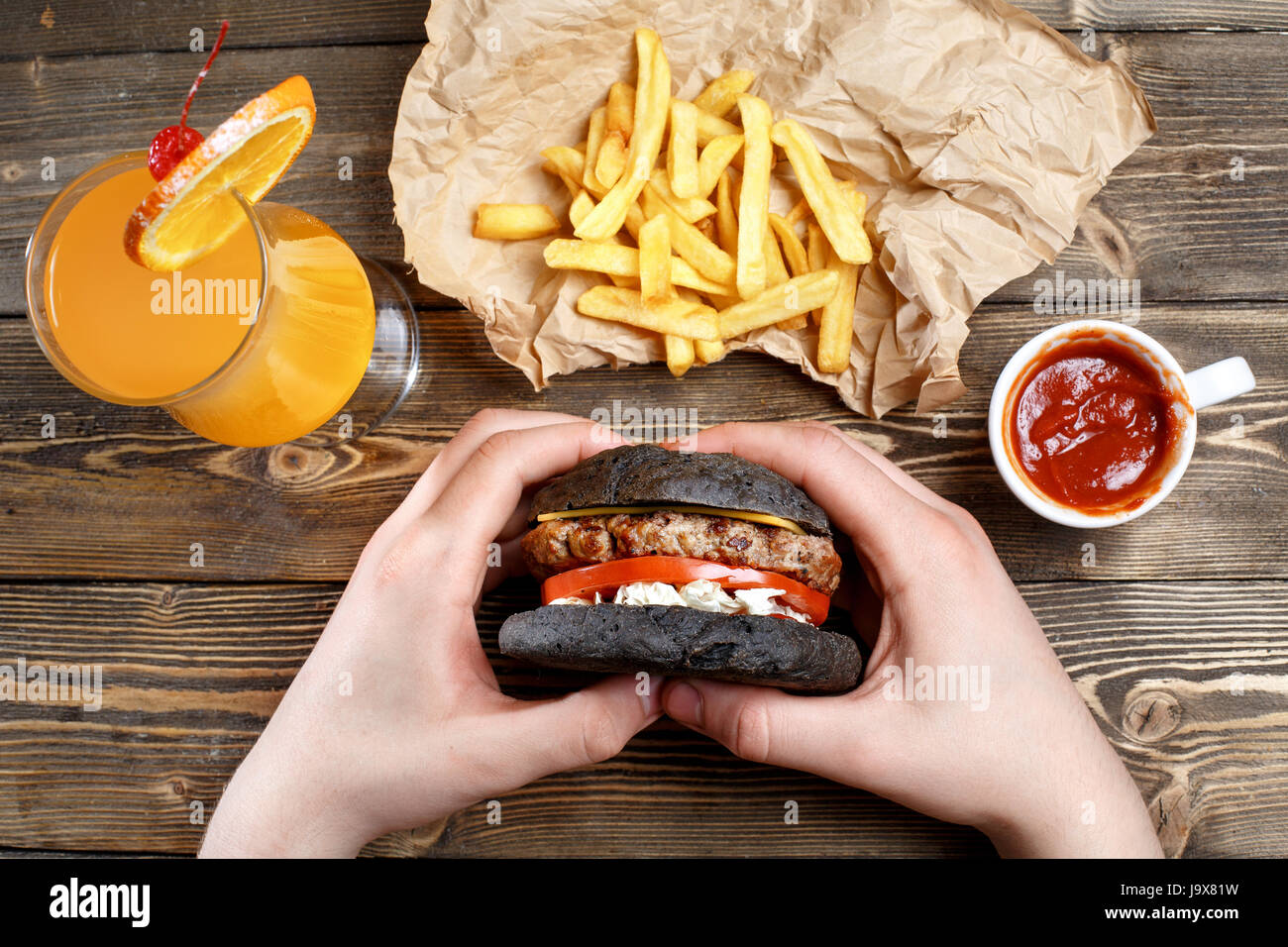 Hände halten frische leckere Burger mit Pommes frites, Soße und frisch ...