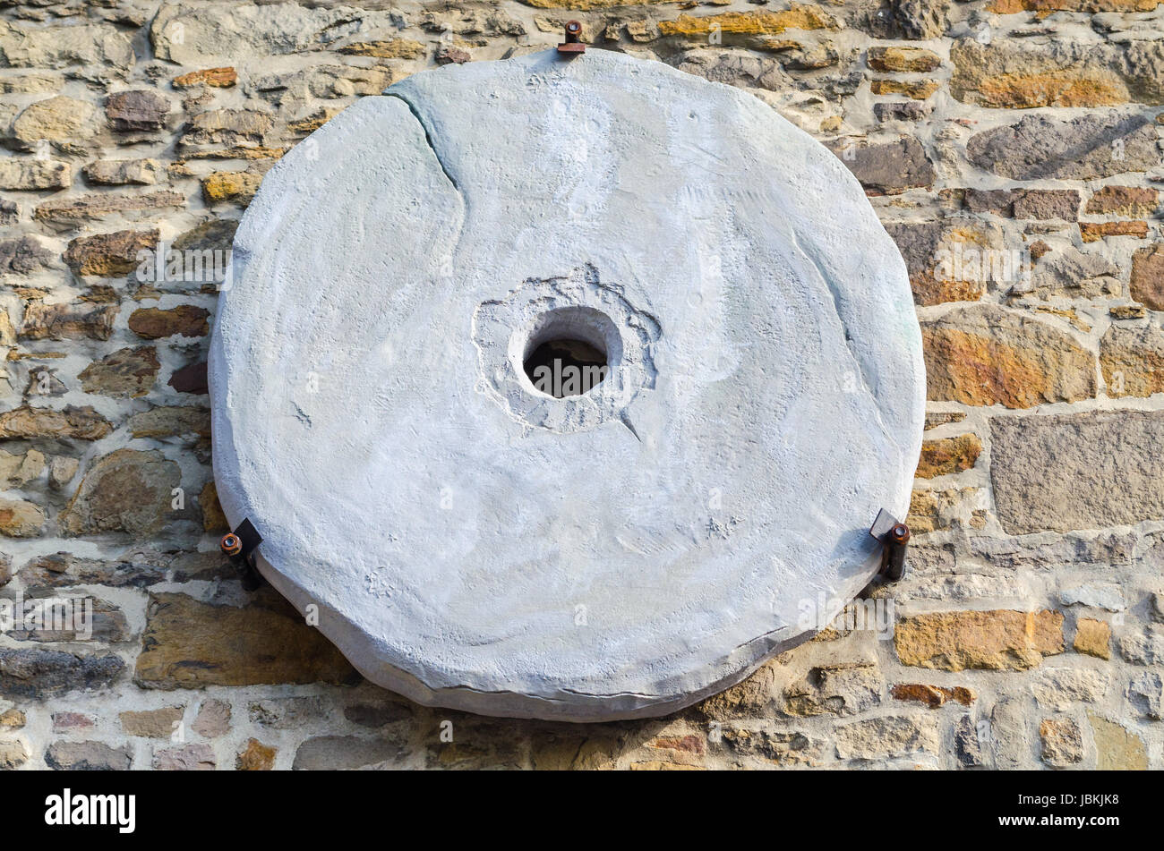 Traditionelle alter Mühlstein ein Einer Bruchsteinwand aufgehangen ...
