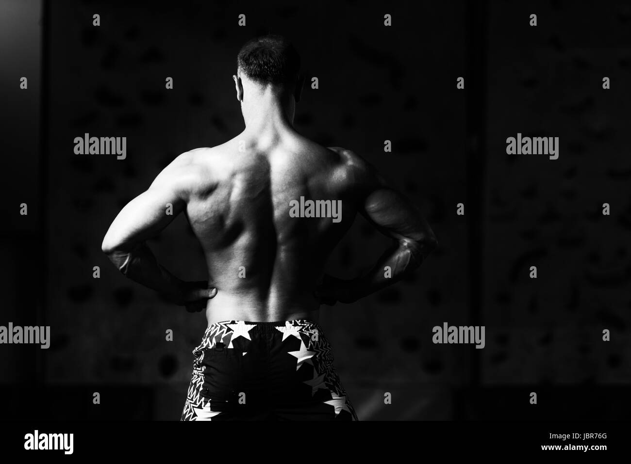 Hübscher junger Mann standhaft In der Turnhalle und biegen Muskeln ...