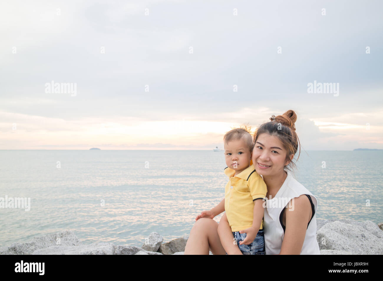 Asiatische junge Pose am Strand mit seiner Mutter, Fotoarchiv Stockfotografie - Alamy